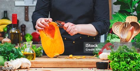 반으로 자른 호박 껍질을 요리하십시오 나무 테이블 주방용품 야채 허브 요리 재료가 있는 아늑한 주방 건강한 비건 채식 요리 조리법 음식 블로깅 가정 주방에 대한 스톡 사진