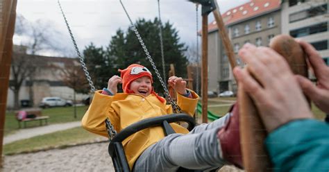 알아볼 수 없는 아버지가 다운 증후군을 앓고 있는 어린 딸을 야외에서 그네로 밀고 있습니다 사진 Unsplash의 운동장 이미지