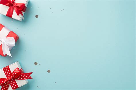 성 발렌타인 데이 장식의 최고 보기 사진 하트 모양의 색종이 빛나는 스팽글과 카피 스페이스와 고립 된 파스텔 블루 배경에 활과 세 개의 선물 상자 0명에 대한 스톡 사진 및