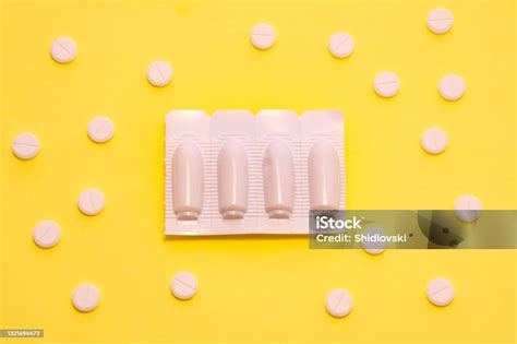 오줌 구의 질병의 좌약의 형태로 제약을 가진 처리 약초의 포장은 노란색 배경에 비뇨기과의 색상 흰색 알약으로 둘러싸여 관장에 대한 스톡 사진 및 기타 이미지 Istock
