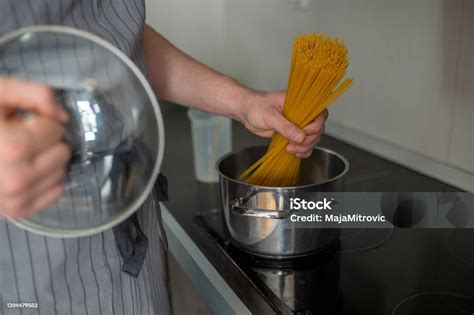 부엌에서 파스타를 준비하는 잘생긴 남자 맛있는 식사를 요리하는 남자 가정 생활에 대한 스톡 사진 및 기타 이미지 가정 생활 가정용 장비 개인 장식품 Istock