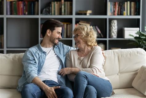 Lycklig Mogen Kvinna Och Ung Man Som Pratar På Soffan Fotografering för Bildbyråer Bild av