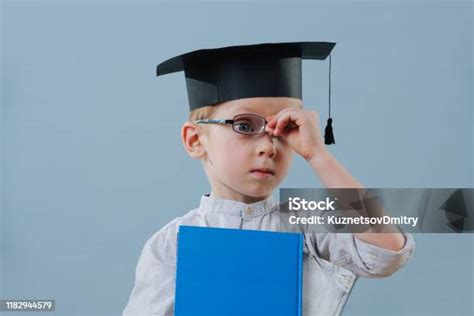 빨간 머리 1 학년 소년 에 학생 모자 와 책 에 손 고정 그의 안경 6 7 살에 대한 스톡 사진 및 기타 이미지 6 7 살 과학 교과서 Istock