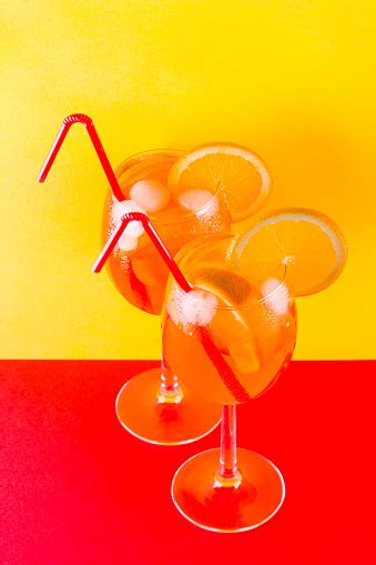 칵테일 아돌 빨간색 노란색 배경에 뿌려 오렌지 조각과 함께 여름 알코올 칵테일 컬러 배경에 아페 롤 스 프리츠 미니 멀리즘 스타일의 산호 색 칵테일 0명에 대한 스톡 사진