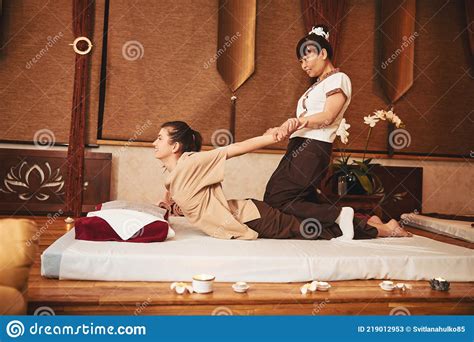 Thai Masseuse Sitting On Woman And Pulling Her Arms Stock Image Image