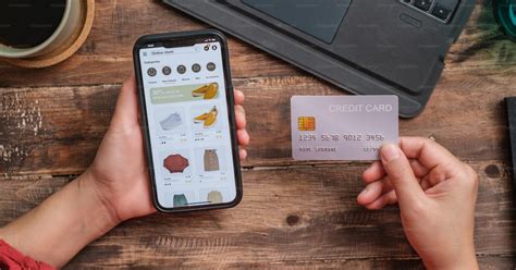 집에서 나무 테이블에 모바일 앱에서 온라인 신용 카드 쇼핑을 사용하는 여자 손을 닫습니다 사진 Unsplash의 옴니채널 이미지