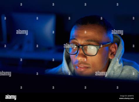 You Can Find Anything Online Nowadays A Young Male Hacker Cracking A Computer Code In The Dark