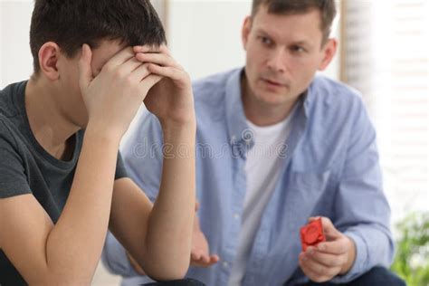 Father Talking With His Teenage Son About Contraception At Home Sex Education Concept Stock