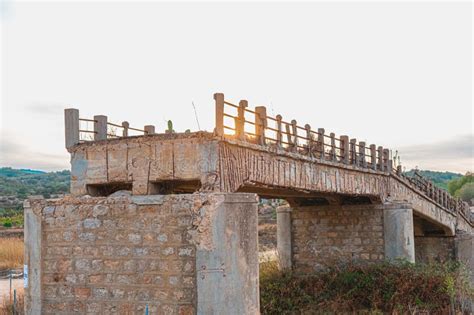 Landscape With An Abandoned Bridge At Sunset With Crumbling Stone And