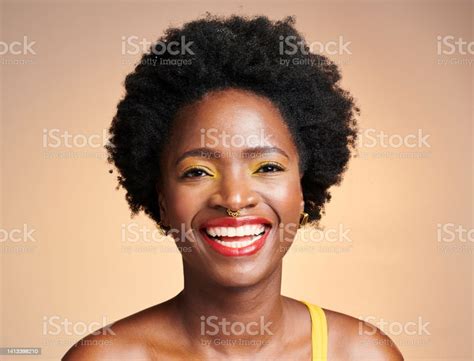 그녀의 얼굴에 화려한 메이크업과 화장품을 가진 아름답고 웃는 젊은 여성 건강한 피부와 자연스러운 머리카락을 즐기는 행복한 여성의 초상화 미소를 짓는 아프리카계 미국인 여성의