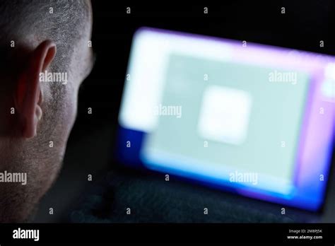 hacking concept male hacker looking at computer screen in dark room