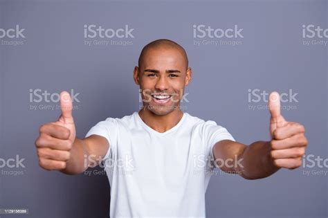 그 그가 그의 대머리를 쇼 엄지 손가락을 승인 조언 사진 강한 건강 한 치아 어두운 피부 가까이 구매 구매자 새 제품 입고 흰색 T셔츠 옷 옷 절연 회색 배경 T 셔츠에