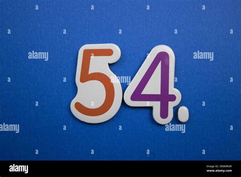 The Number 54 Placed On A Blue Background Photographed From Above