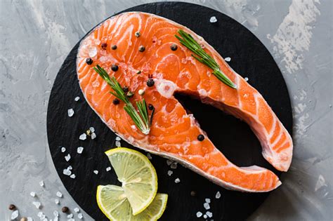 어두운 돌 배경에 향신료와 신선한 생 연어 생선 스테이크 물고기 상단보기 플랫 레이 모형 오버 헤드로 만든 창조적 인 레이아웃 건강한 음식 개념 건강한 식생활에 대한 스톡