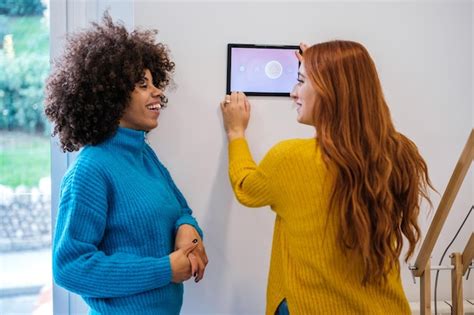 Premium Photo Couple Of Women Installing A Central Control Computer For The House Concept