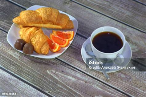 접시에 오렌지 조각과 초콜릿이 있는 두 개의 크루아상 테이블에 스푼이 있는 접시에 검은 커피 한 잔 클로즈업 0명에 대한 스톡 사진 및 기타 이미지 Istock