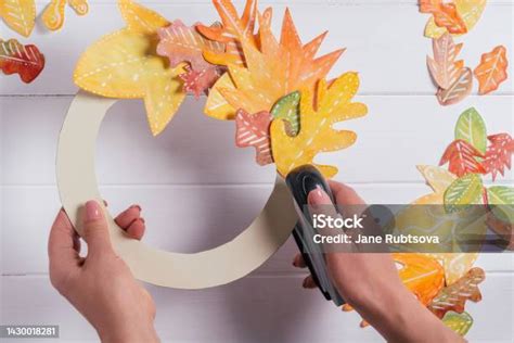 장식용 가을 종이 화환을 만드는 여성 손 스테이플러를 사용하여 골판지 형태로 원형으로 잎을 고정하십시오 위쪽 보기 Diy에 대한 스톡 사진 및 기타 이미지 Istock