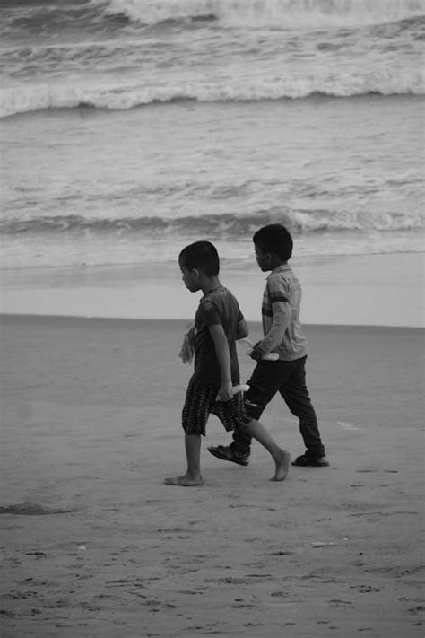 흑백으로 해변을 걷는 아이들 · 무료 스톡 사진