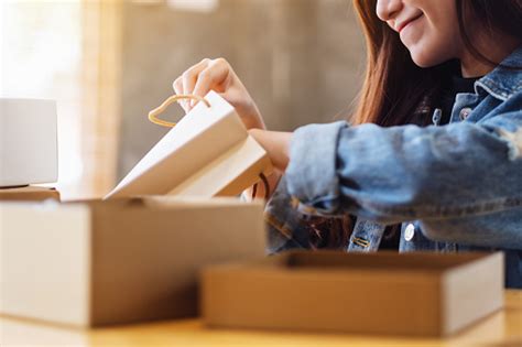 배달 및 온라인 쇼핑 컨셉을 위해 집에 있는 테이블에 우편 소포 상자가 있는 쇼핑백 내부를 열고 바라보는 여성 가방에 대한 스톡 사진 및 기타 이미지 Istock
