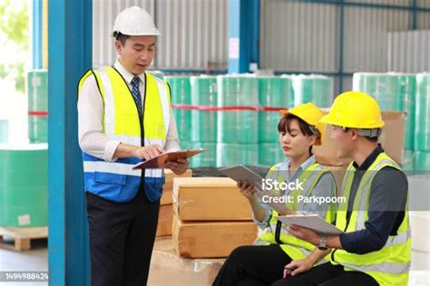 보호복을 입은 기술자 엔지니어와 사업가 그룹이 서서 산업 제조 공장에서 태블릿과 함께 토론하고 연구하고 브레인스토밍하고 계획을 세운다 20 24세에 대한 스톡 사진 및 기타