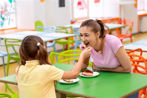 엔터테인먼트 센터의 아늑한 카페에서 어린 엄마에게 맛있는 케이크를 먹이는 십대 소녀 함께 가족 주말 보내기 2명에 대한 스톡 사진 및 기타 이미지 Istock