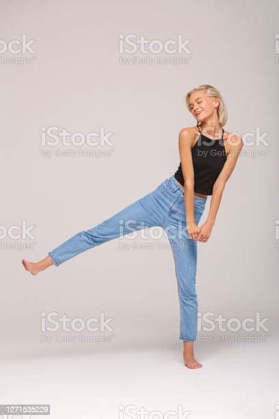 자유형 젊은 금발의 여자 청바지와 상단에 서 에 한 쪽 다리 고립 된 에 흰색 전신 샷 폐쇄 눈 유쾌한 20 24세에 대한 스톡 사진 및 기타 이미지 Istock