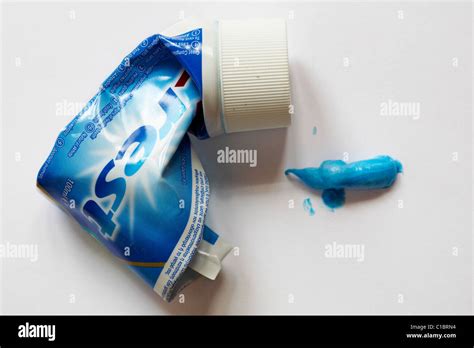 Old Tube Of Crest Toothpaste With Toothpaste Blob Isolated On White