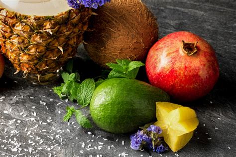 잘 익은 석류 석 밝은 아보카도 코코넛 파인애플 및 Carambola 코 코 칩 꽃과 민트 회색 배경에 나뭇잎 0명에 대한 스톡 사진 및 기타 이미지 Istock