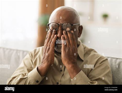 Senior African Man Rubbing Eyes Wearing Eyeglasses Having Glaucoma
