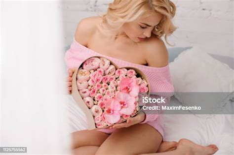 분홍색 셔츠의 장미 색된 모란 난초와 장미 하트 모양 상자를 들고 침대에 앉아 있는 여자 개화기에 대한 스톡 사진 및 기타 이미지 개화기 공휴일 금발 머리 Istock