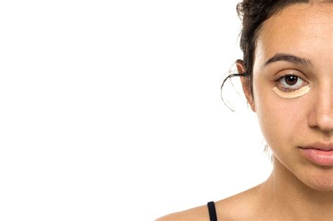 눈 밑에 컨실러를 가진 젊은 여성의 절반 초상화 무채색의 표정 짙은 곱슬머리 흰색 배경에 자연의 아름다움을 강조하는 클로즈업 스튜디오 샷 20 24세에 대한 스톡 사진 및