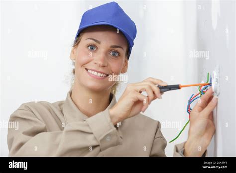 Female Electrician Using Electric Screwdriver To Test Socket Stock Photo Alamy