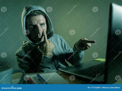 Dangerous Looking Hacker Man In Hoodie Hacking Internet Computer System Pointing His Eyes