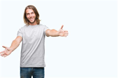 포옹에 대 한 두 팔을 벌려 웃 고는 카메라를 보고 하는 고립 된 배경 위에 긴 머리를 가진 젊은 잘생긴 남자 명랑 식 수용 행복입니다 광대한에 대한 스톡 사진 및 기타