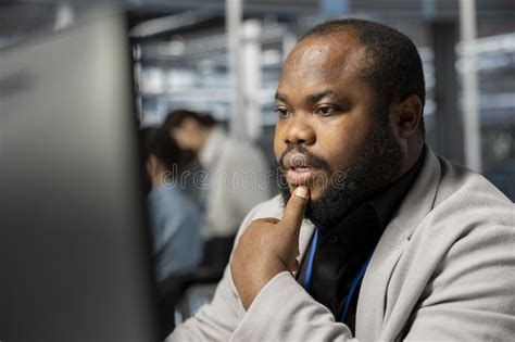 Man Working In Data Center Analyzing Software Logs Metrics On Pc Stock
