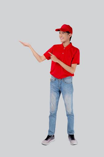 유니폼 빨간색과 모자를 쓴 젊은 아시아 남자는 흰색 배경 직원 또는 딜러 쇼 택배 및 배달 배달원 및 표현 물류 및화물에 고립