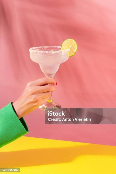 분홍색 노란색 배경 위에 고립 된 맛있는 마가리타 칵테일 한 잔을 들고있는 여성의 손 건배 칵테일에 대한 스톡 사진 및 기타 이미지 Istock