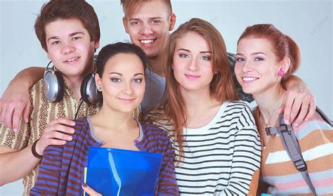 Smiling Students Clutching Notebooks In A White Backdrop Photo