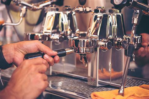 커피 바리스타 커피 메이커 핫컵에서 에스프레소 샷을 만들어보세요 카푸치노와 이탈리아 커피숍 카페 바리스타 사용 기계의 손을 닫는 것은 고객 카페테리아를위한 갈색 라떼 예술을