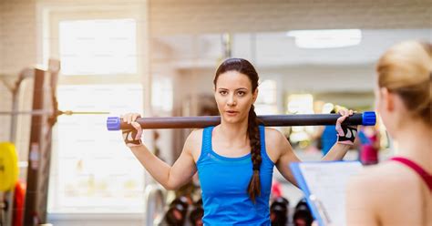 파란색 싱글릿을 입은 여자는 개인 트레이너와 함께 체육관에서 바에서 운동하고 있으며 클립보드의 운동 계획에 글을 쓰고 있다 사진 Unsplash의 운동하는 여자 이미지