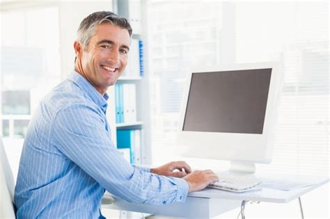 Premium Photo Smiling Man Typing On Keyboard And Looking At Camera