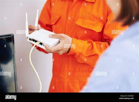 Close Up Image Of Electrician Explaining Woman How To Use Wi Fi Router