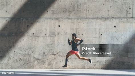 근육 질의 남성 운동 선수 단거리 주자 야외에서 운동 빠른 실행 텍스트 메시지 또는 광고 콘텐츠에 대 한 복사 공간 영역을 배경으로 회색 콘크리트에 대해 외부 조깅 측면
