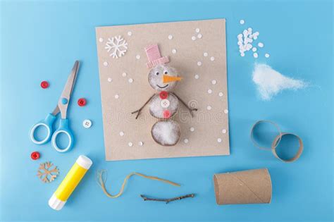 A Craft Project Featuring A Snowman Made From Various Materials On Brown Paper With Buttons