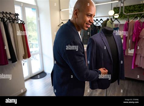 joyous fashion designer drawing vertical line with chalk on suit jacket