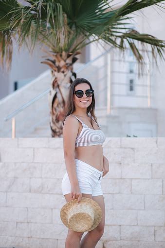 열대에서 수영복과 반바지에 아름다운 젊은 여자입니다 모자와 선글라스를 쓴 여성 직업 개념 듣기에 대한 스톡 사진 및 기타 이미지