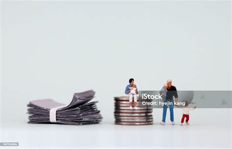 아기 옆에 아기와 함께 청구서 및 소형 남자의 더미 옆에 동전 더미에 앉아 미니어처 여자 작은에 대한 스톡 사진 및 기타 이미지 작은 비용 개념 사람들 Istock