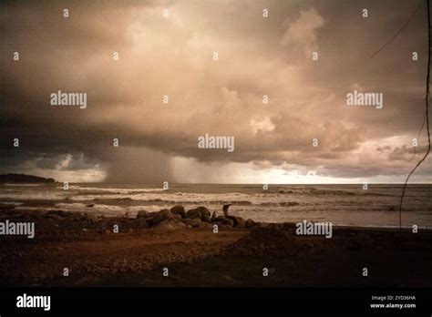 Stormy Rainclouds And Rainfall Over Indian Ocean Are Seen From A Beach