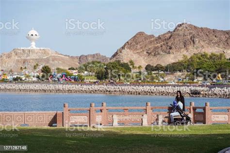 무스카트의 코니쉬에서 아기를 안고 있는 무슬림 가족과 물 전망 리얌 향버너를 배경으로 가정 생활에 대한 스톡 사진 및 기타