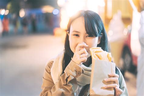 Young Adult Asian Woman Holding Japanese Sweet At Outdoor Travel Street Food On Winter Stock